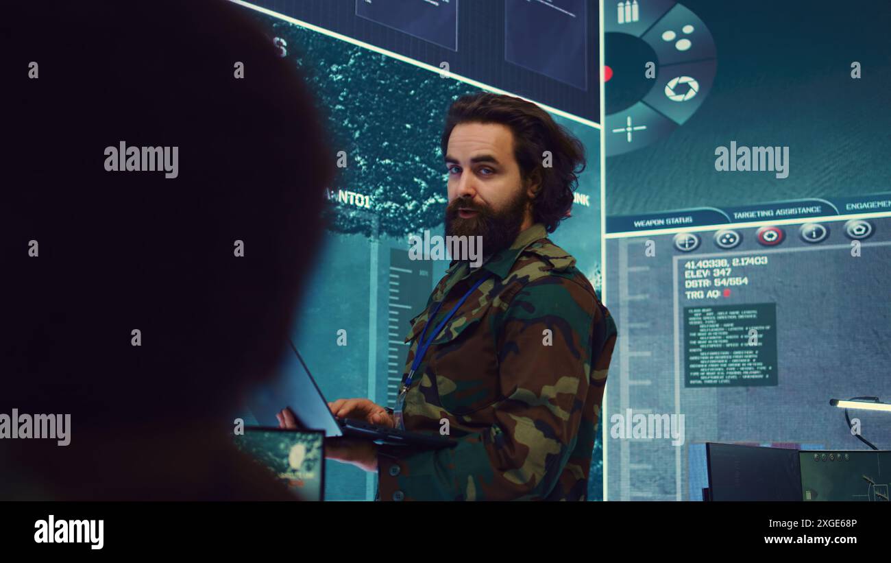 Army major monitoring data on a big screen in military command center ...
