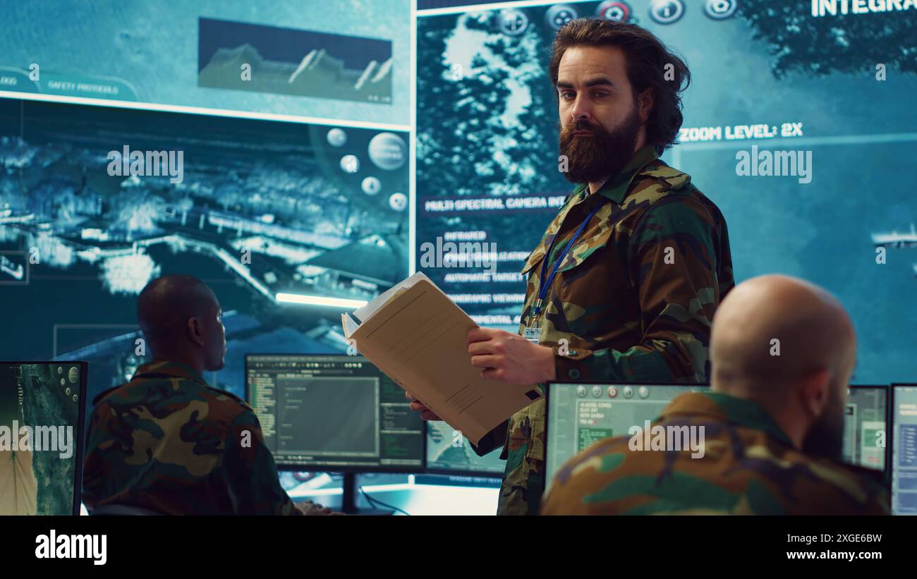 Army major reads operation details from a case file in a control center ...