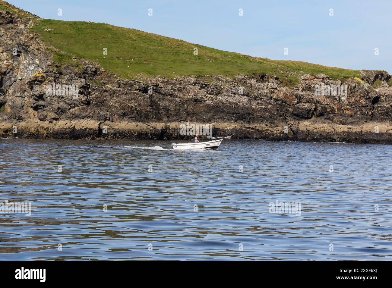 Lobster fishing loal fisherman boat Ireland sailing past rocky coast ...