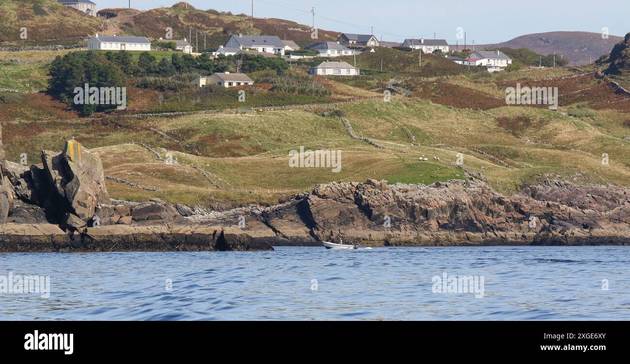 Inshore coastal fishing Ireland man in small white inshore fishing boat ...