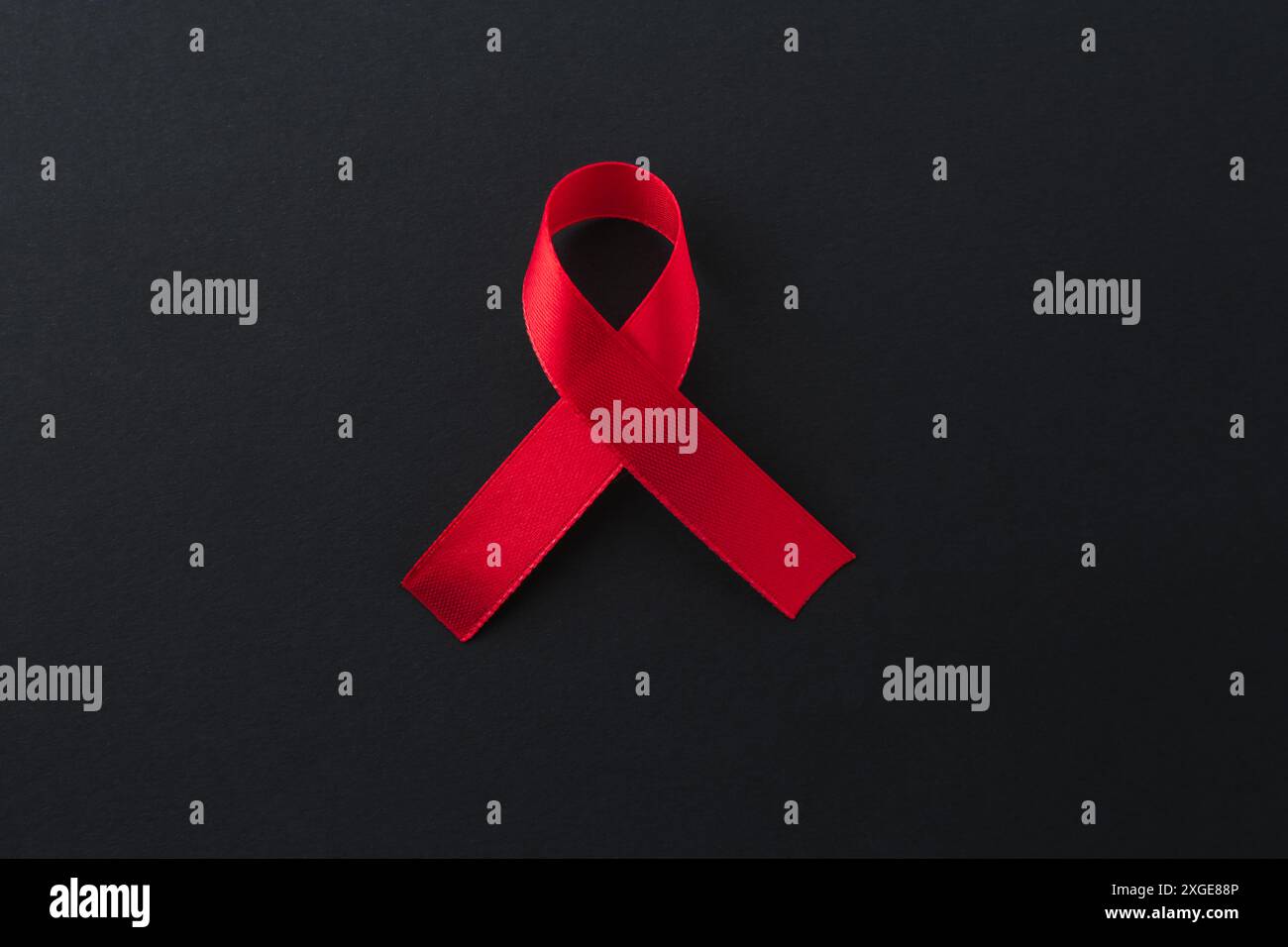 Red awareness ribbon on black background, top view Stock Photo - Alamy