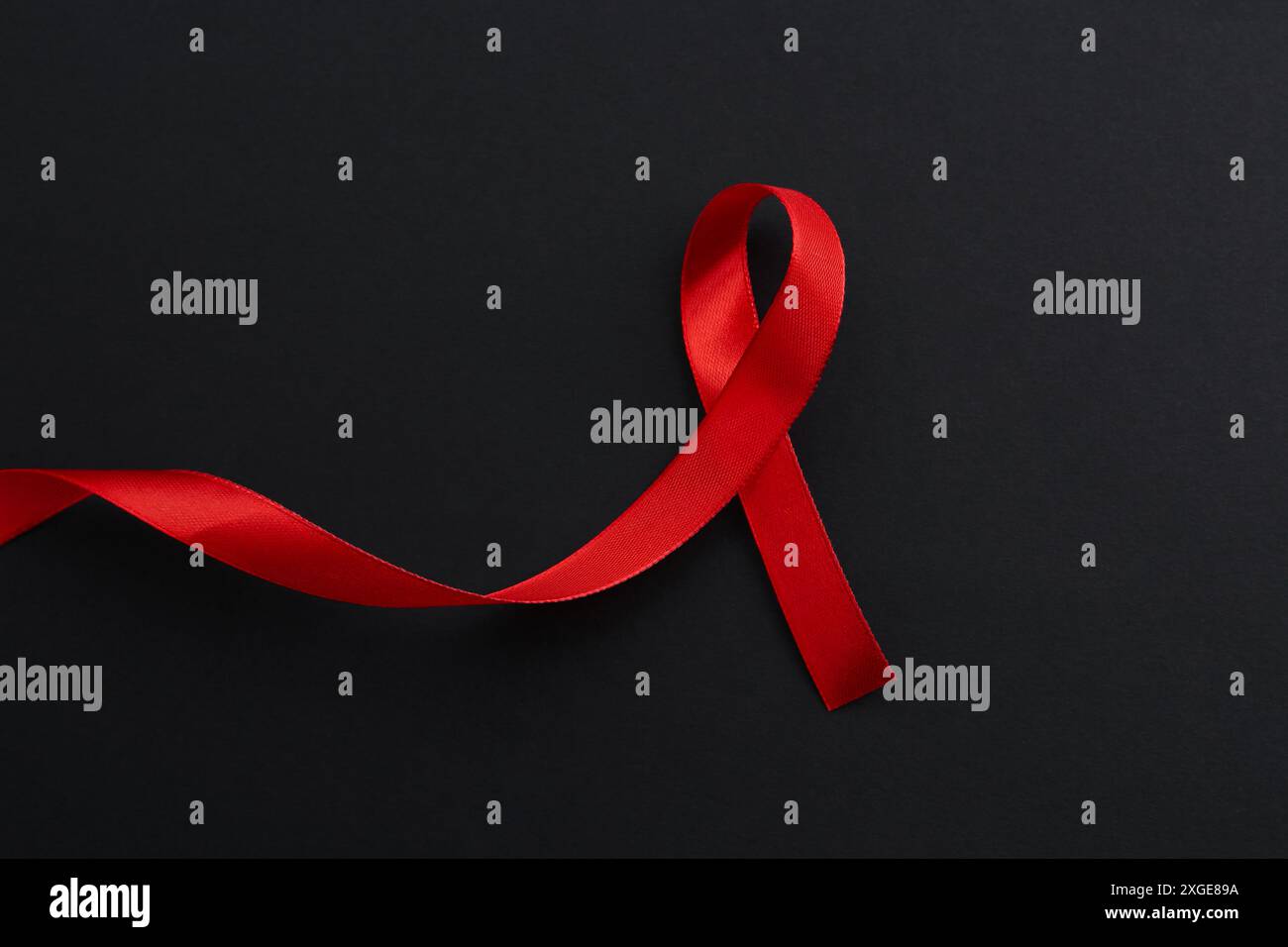 Red awareness ribbon on black background, top view Stock Photo - Alamy