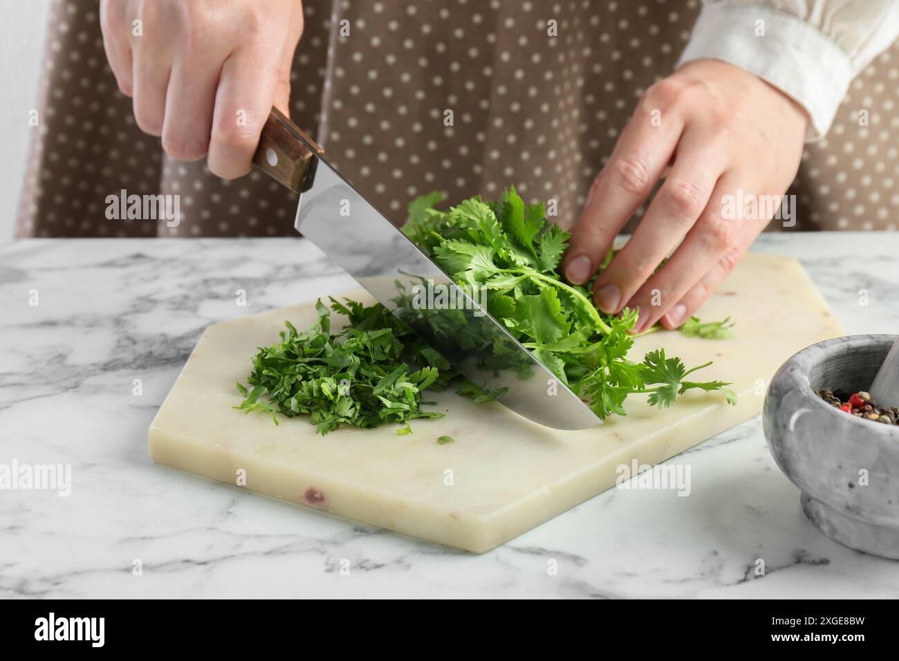 Woman cutting fresh coriander at white marble table, closeup Stock ...