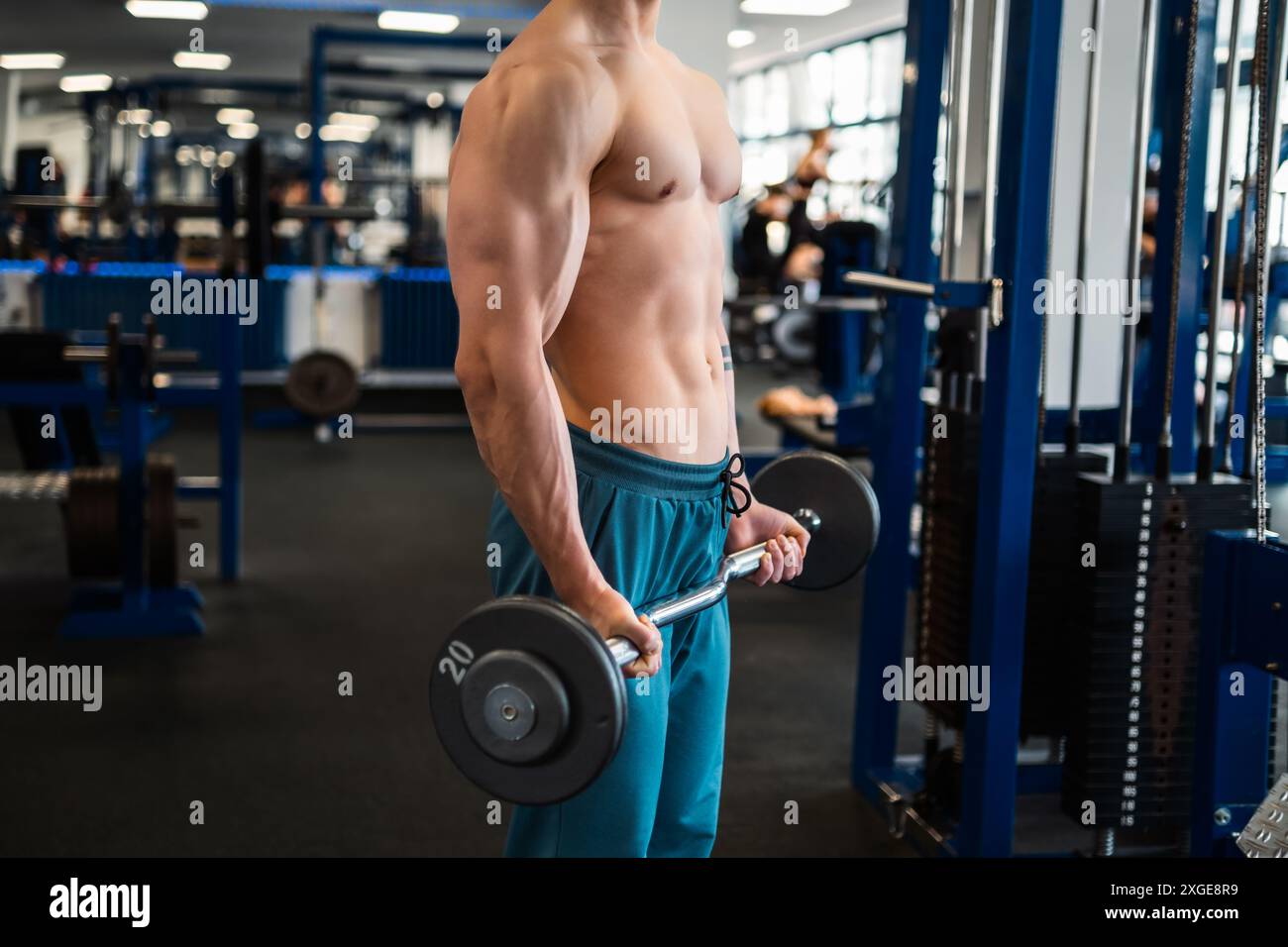 A bodybuilder lifts weights using barbell in a gym Stock Photo - Alamy