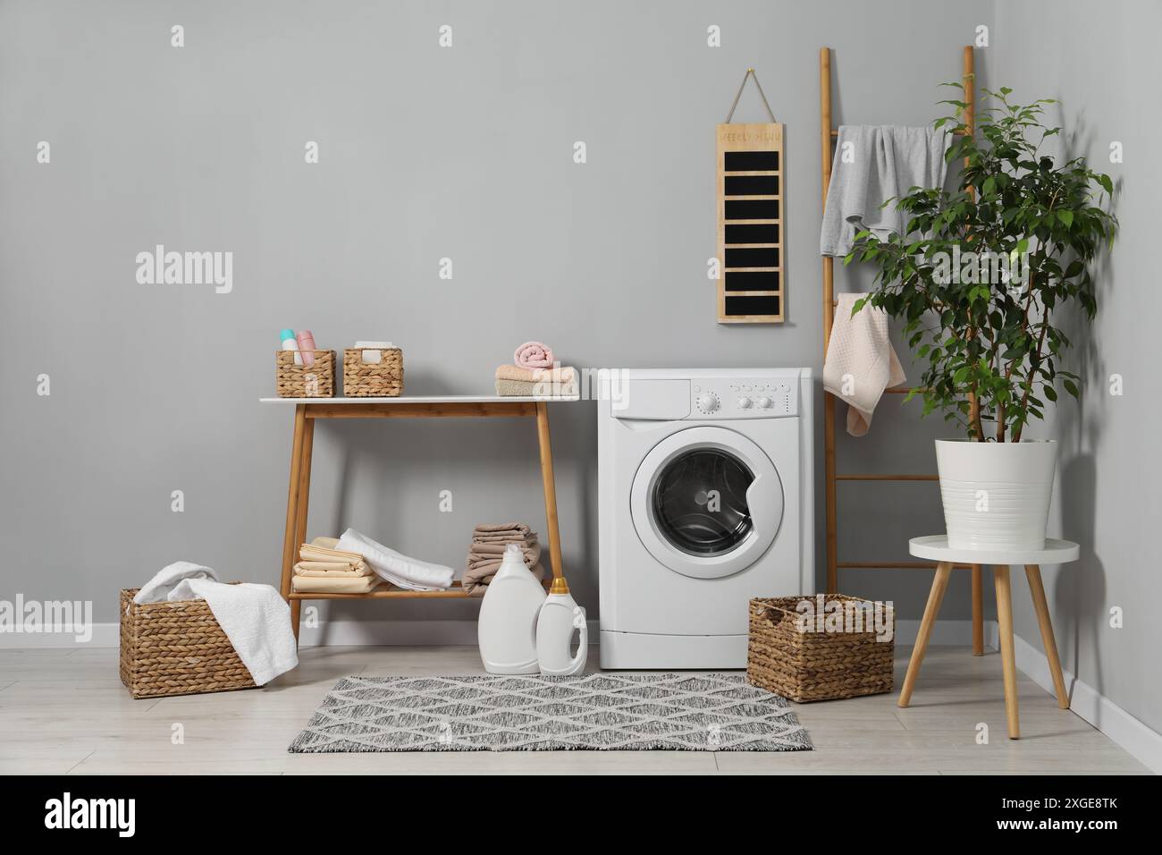 Washing machine, storage bench, detergents, laundry and houseplant ...