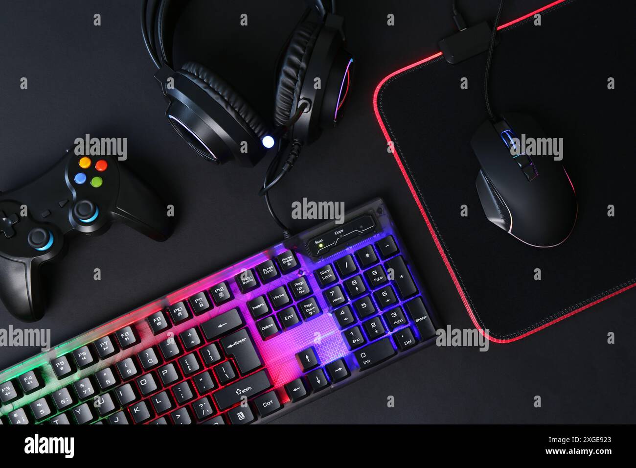 Computer mouse, RGB keyboard, game controller and headset on black ...