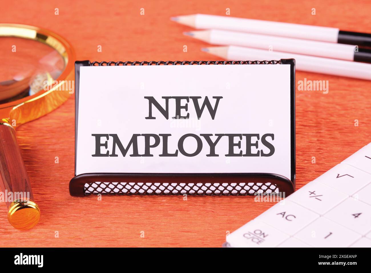 NEW EMPLOYEES word written on a white business card on an orange ...