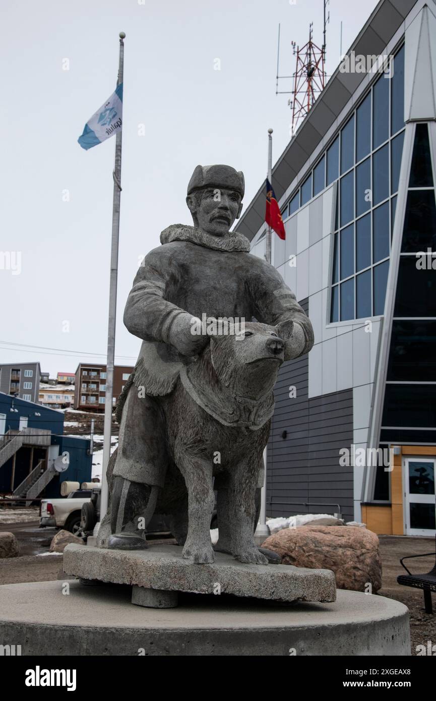 Stone sculpture carving of an Inuit man and dog at the RCMP building on ...