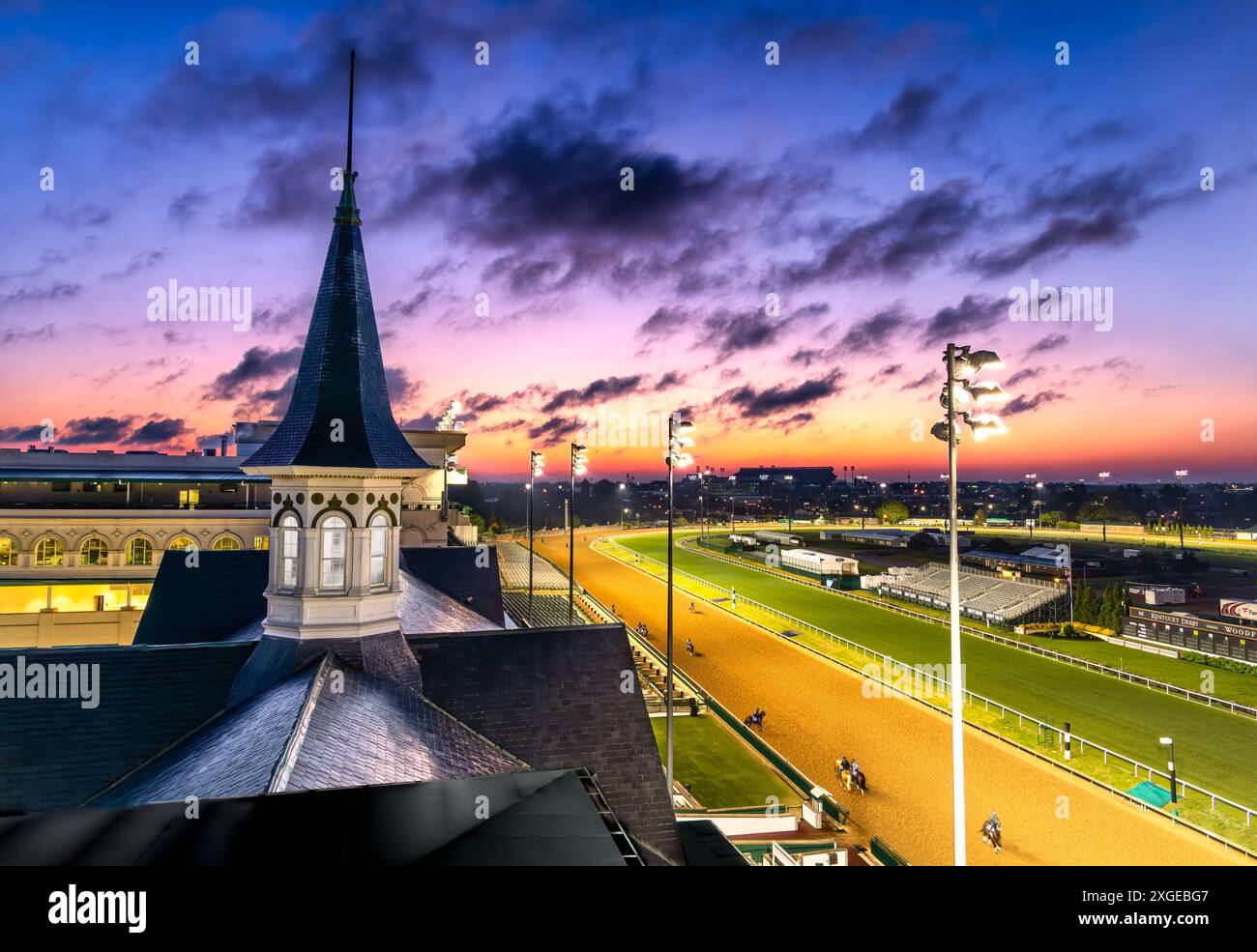A stunning view of Churchill Downs racetrack at sunset with a colorful sky and iconic twin ...