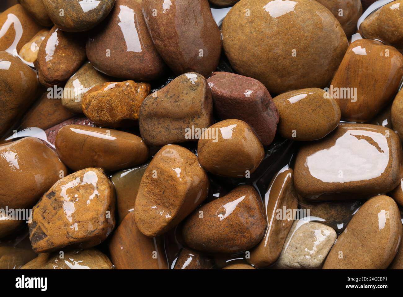 Beautiful pebbles in water as background, top view Stock Photo - Alamy