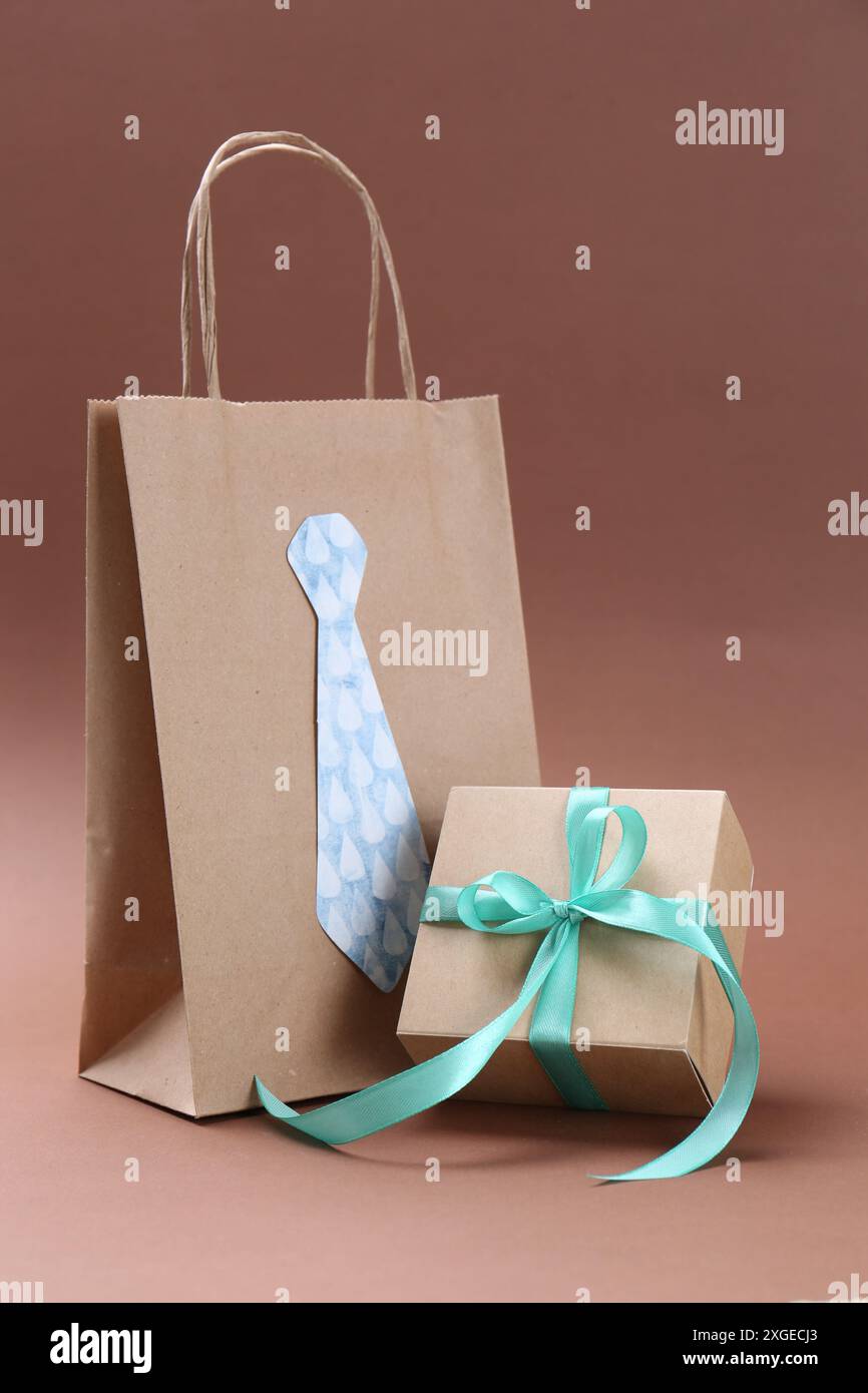 Happy Father's Day. Paper bag with tie and gift box on light brown ...