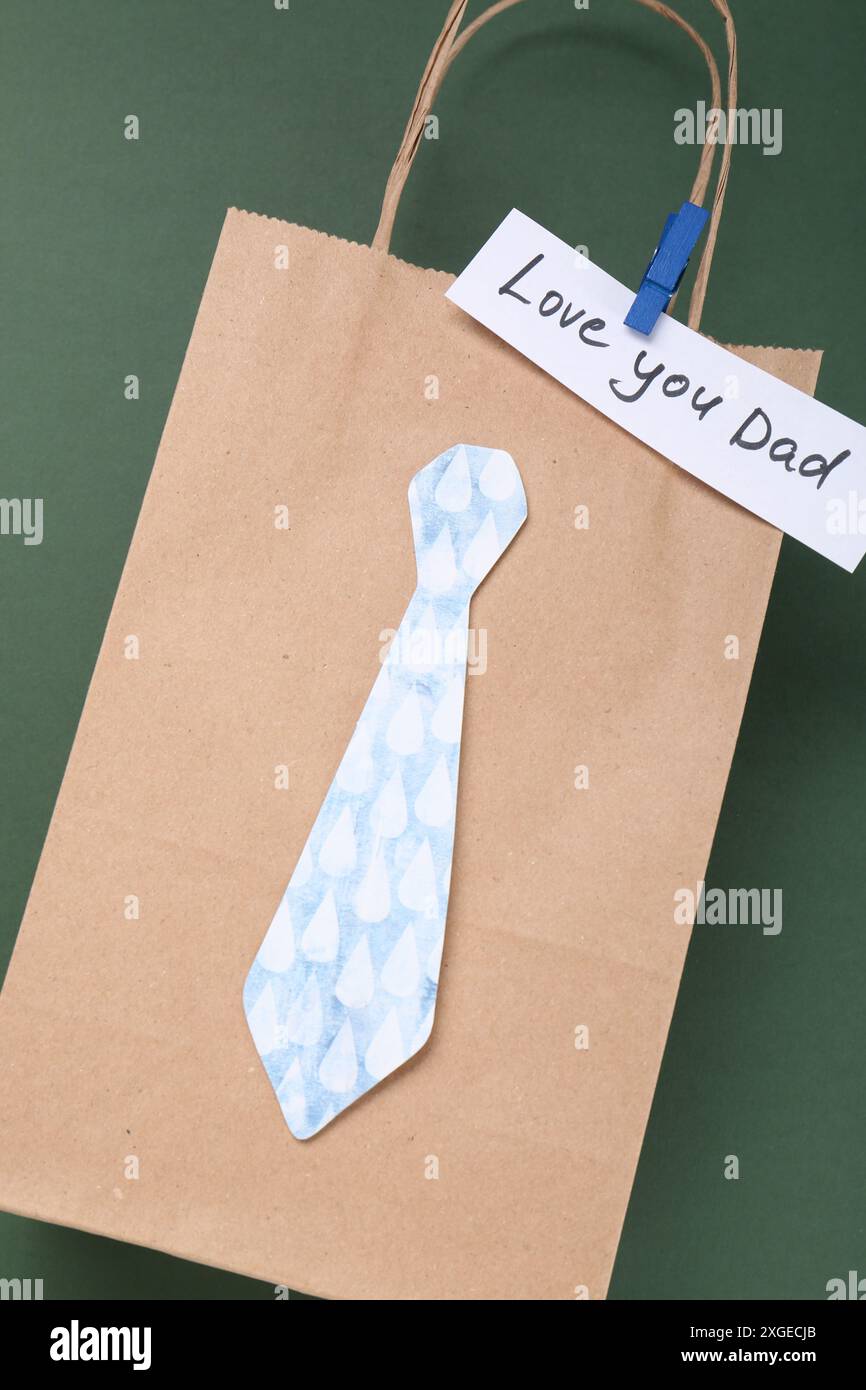 Happy Father's Day. Paper bag with tie and phrase Love You Dad on green ...