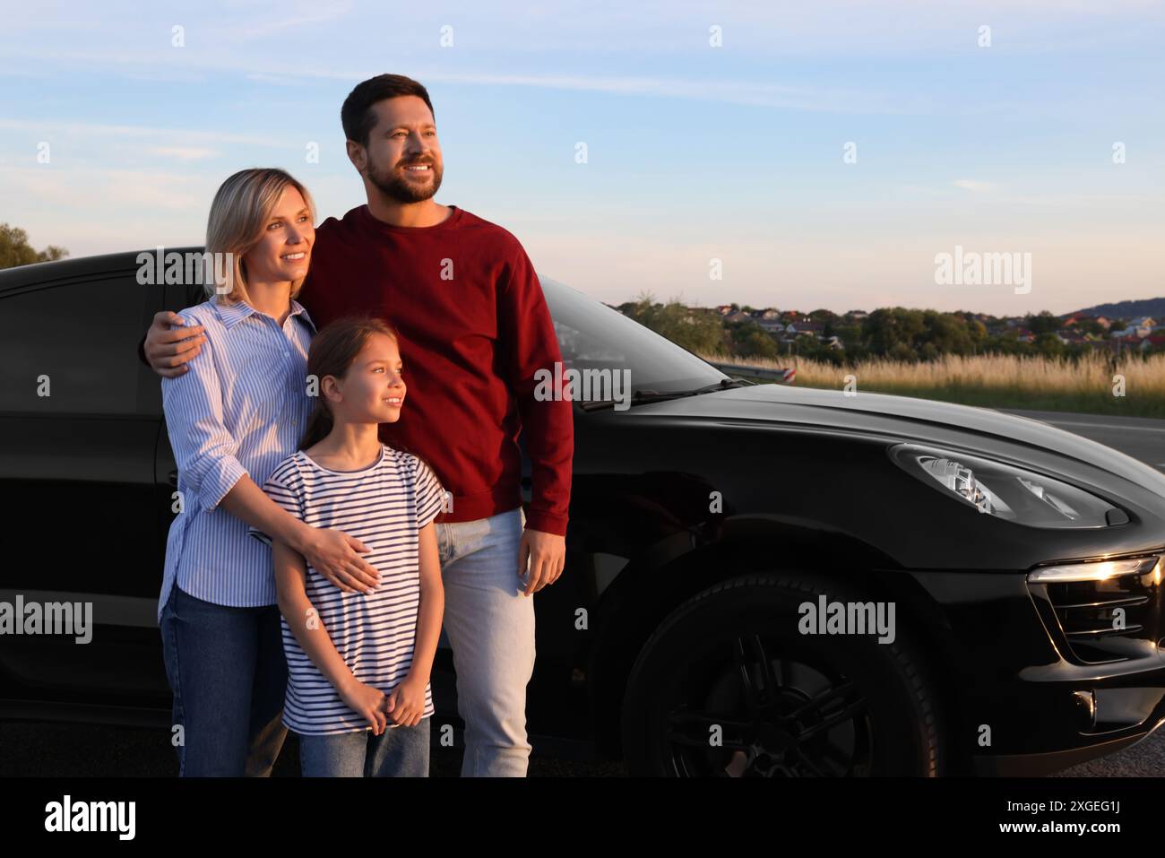 Happy parents and their daughter near car outdoors Stock Photo - Alamy