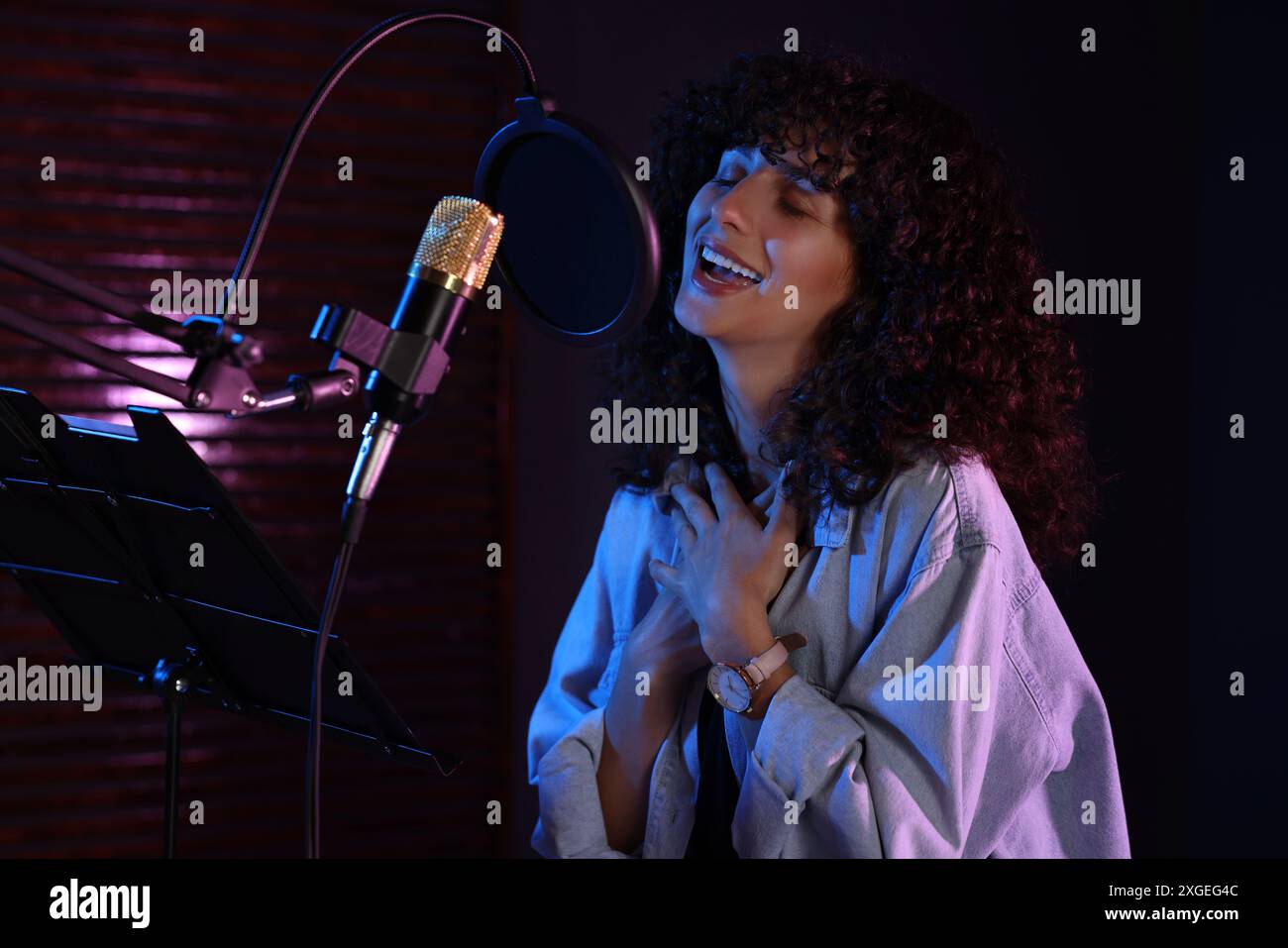 Vocalist singing into microphone in professional record studio Stock ...