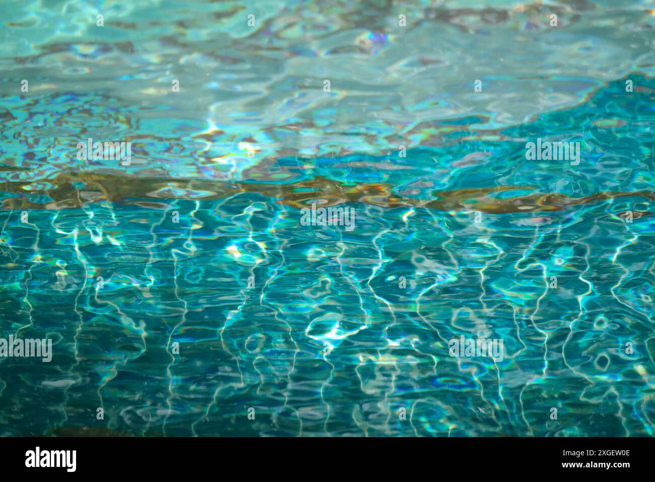 Swimming pool rippled water with sun reflections. Abstract background ...