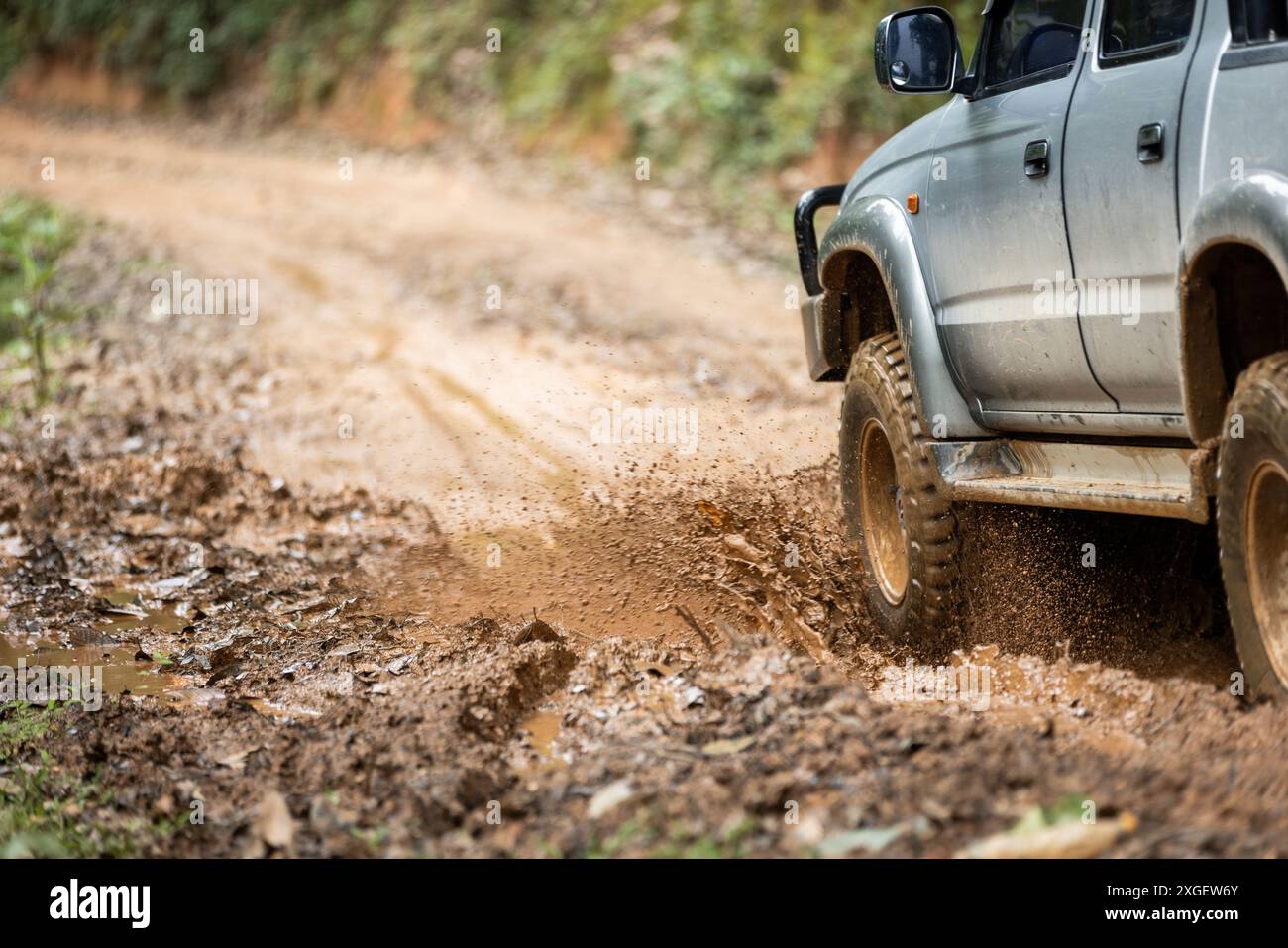 Cars running on off-road roads and splashing mud on natural paths. Off ...