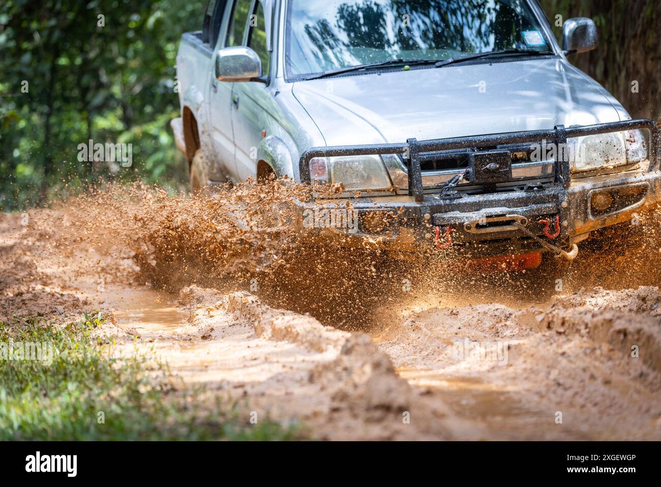 Cars running on off-road roads and splashing mud on natural paths. Off-road travel on muddy road ...