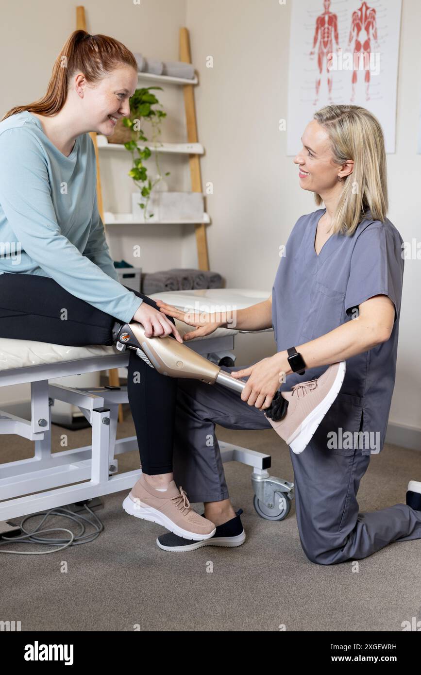 Physical therapist adjusting prosthetic leg for woman in medical clinic ...