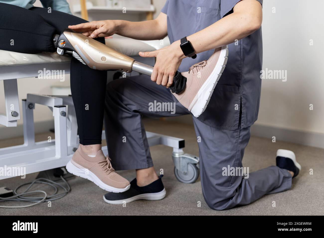 Adjusting prosthetic leg, technician assisting patient in medical ...