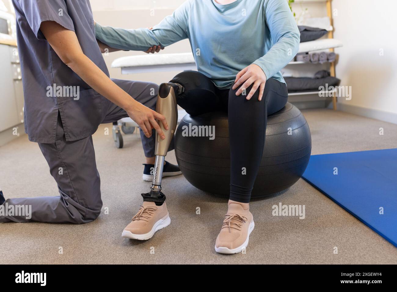Physical therapist adjusting prosthetic leg for patient sitting on ...