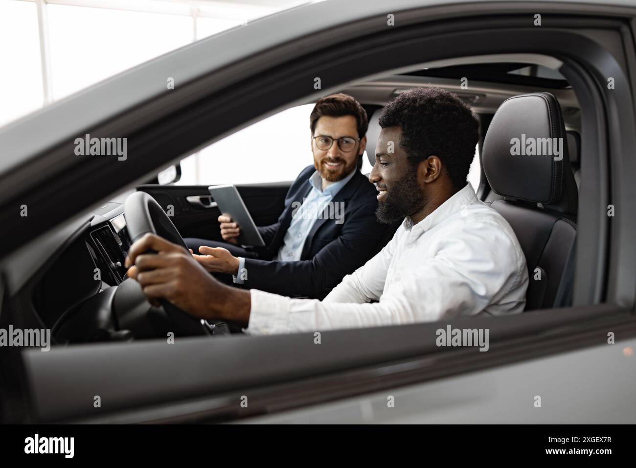 Car dealer assisting customer with vehicle purchase inside car Stock ...