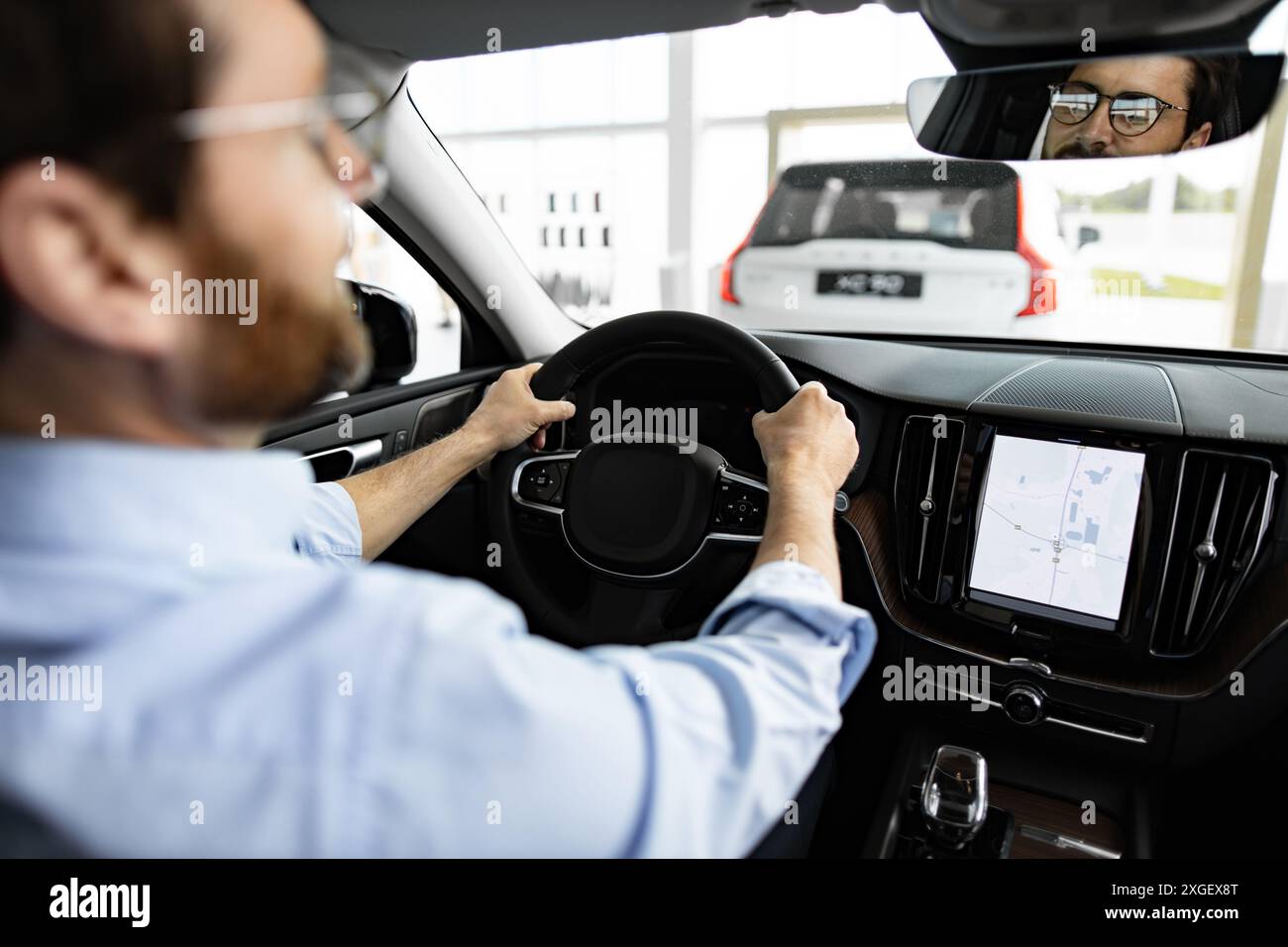 Businessman test driving new car with navigation system in dealership ...