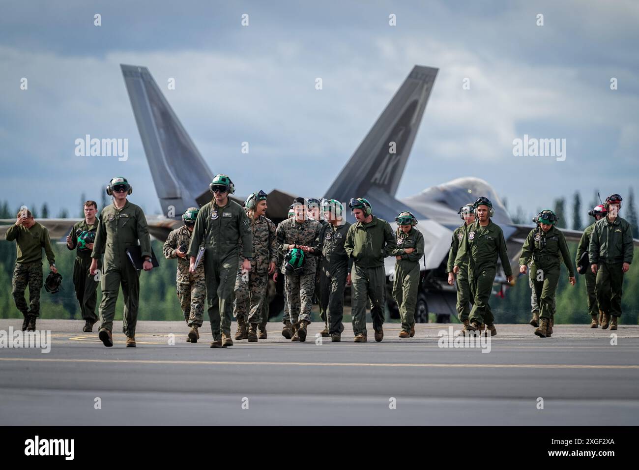 08 July 2024, USA, Fairbanks: US soldiers walk past an F-22 fighter jet ...