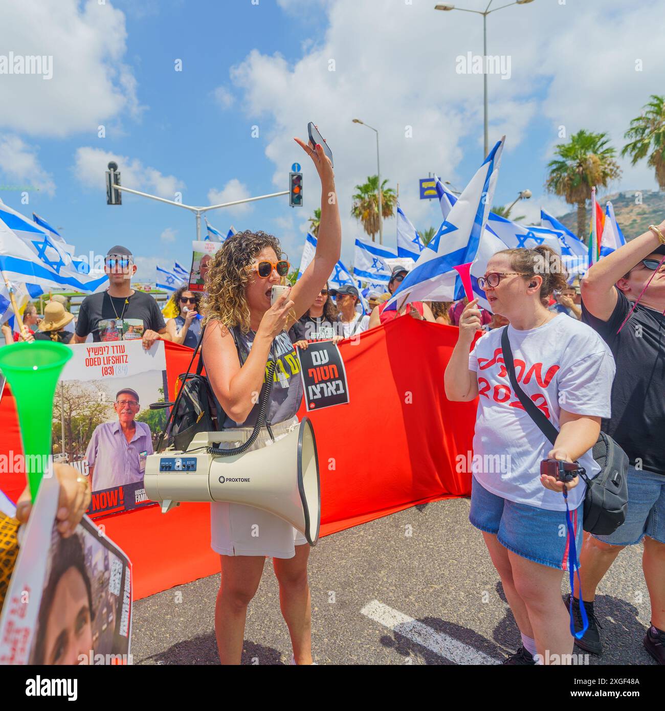 Haifa, Israel - July 07, 2024: People protest with flags, various signs ...