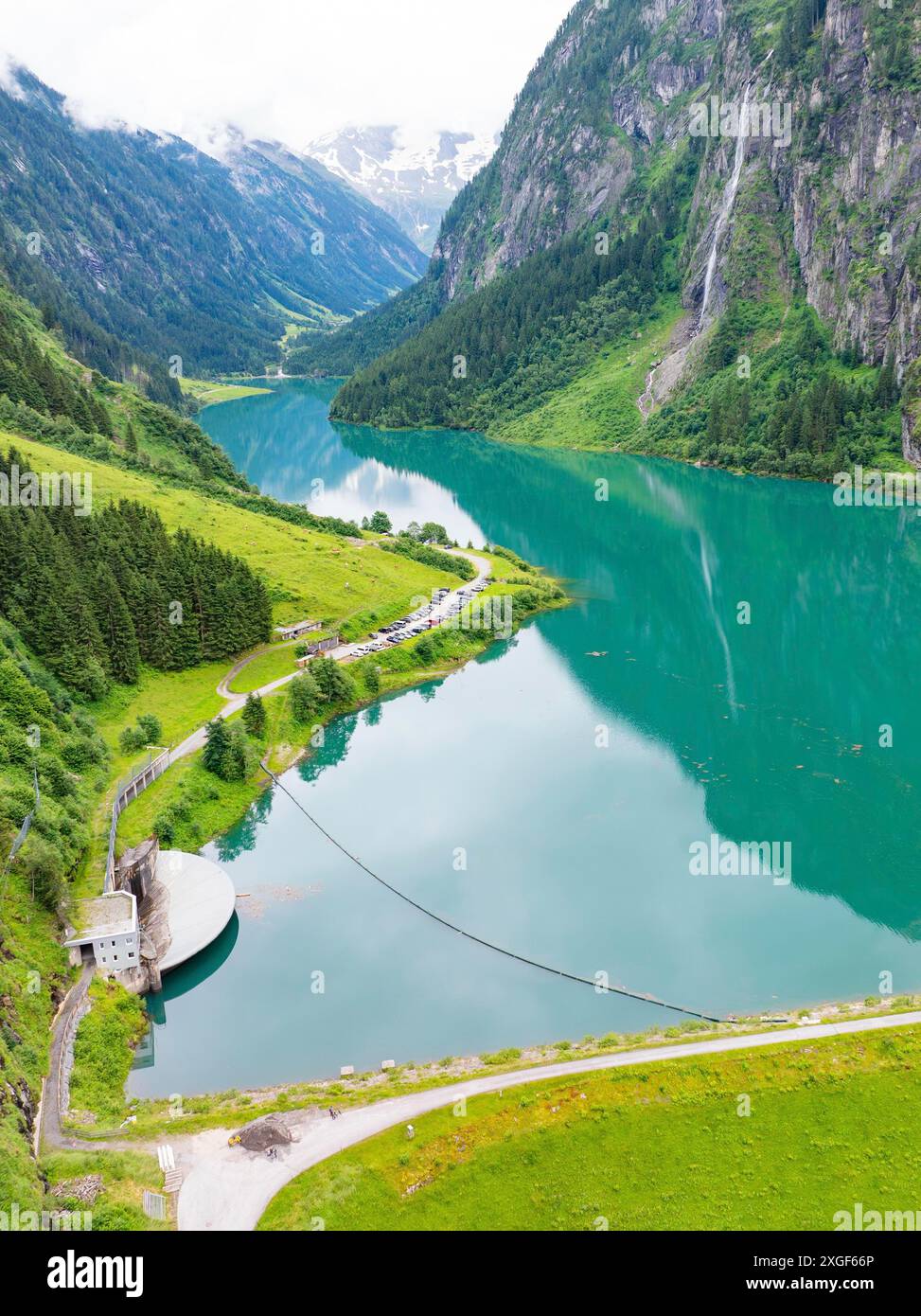 An idyllic mountain lake surrounded by lush greenery and steep ...