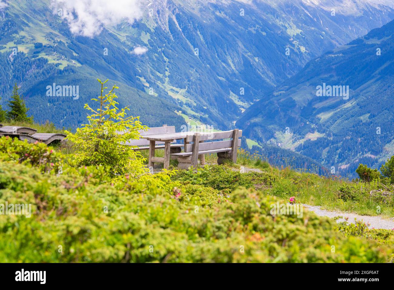 A bench on a hill with a view of the impressive mountain landscape ...