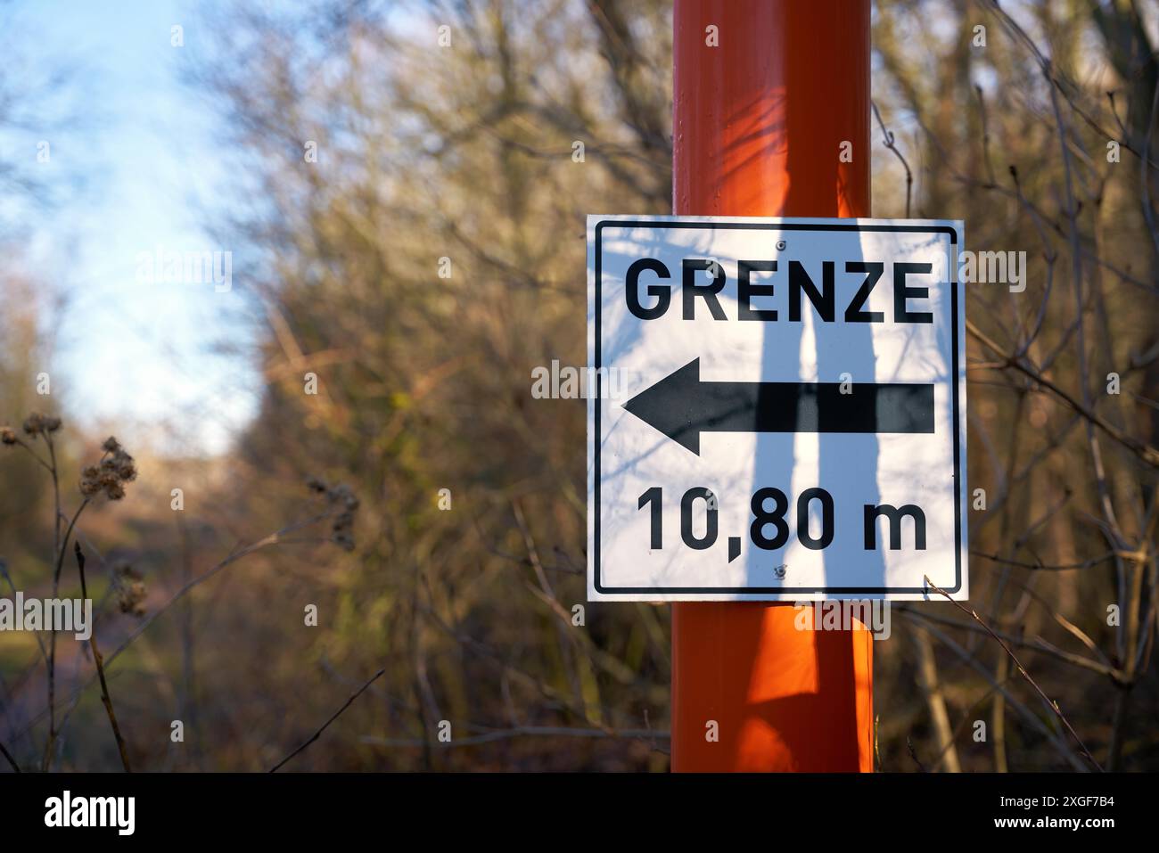 Sign with directional arrow and the inscription Grenze 10, 80 metres ...
