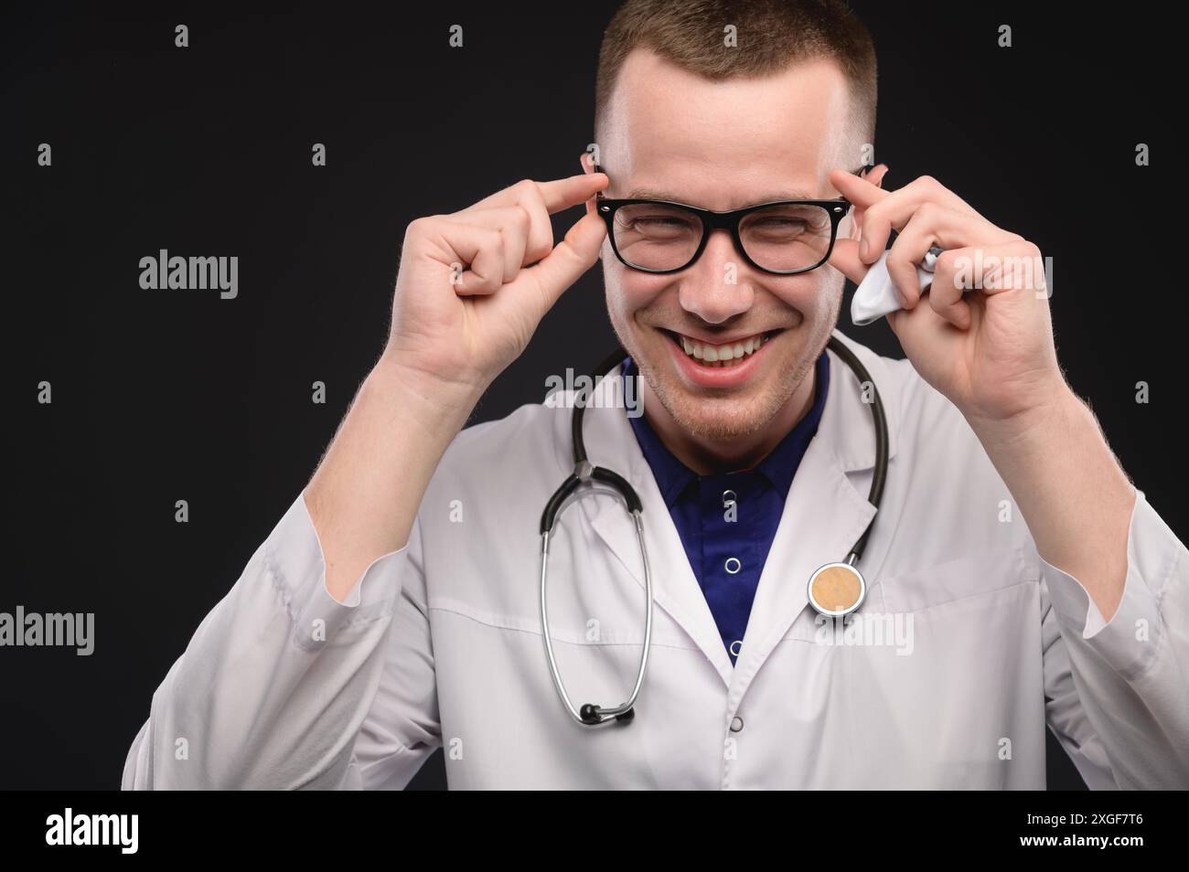 Studio portrait of a positive laughing young doctor in a white coat ...