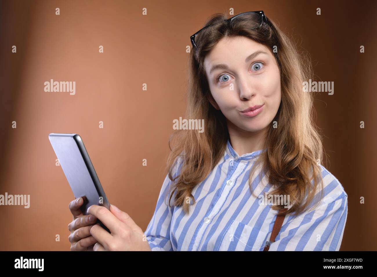 Pretty business woman having fun doing fish lips with a laptop at the ...