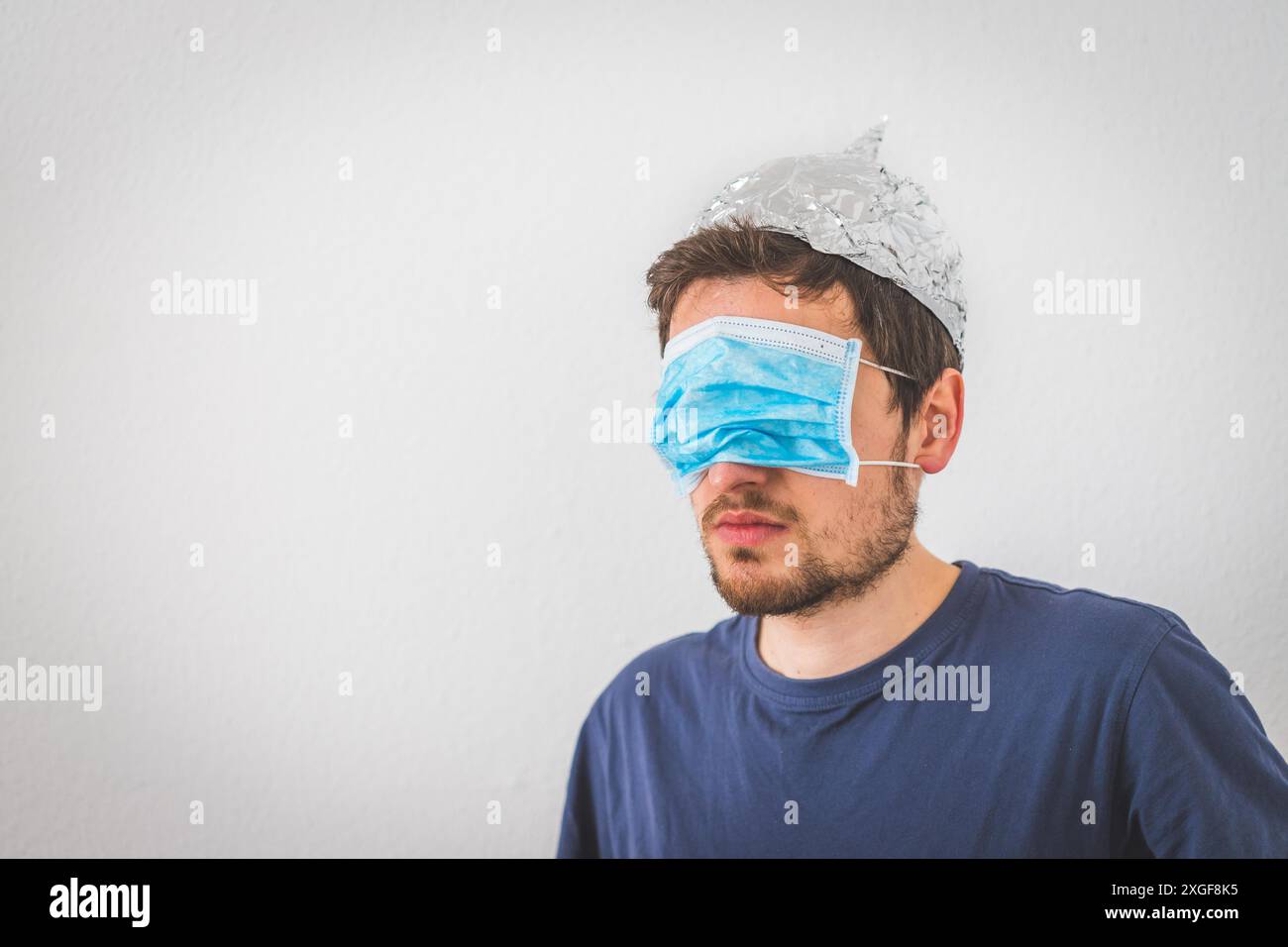 Young angry man with aluminum cap and face mask. Conspiracy theory ...