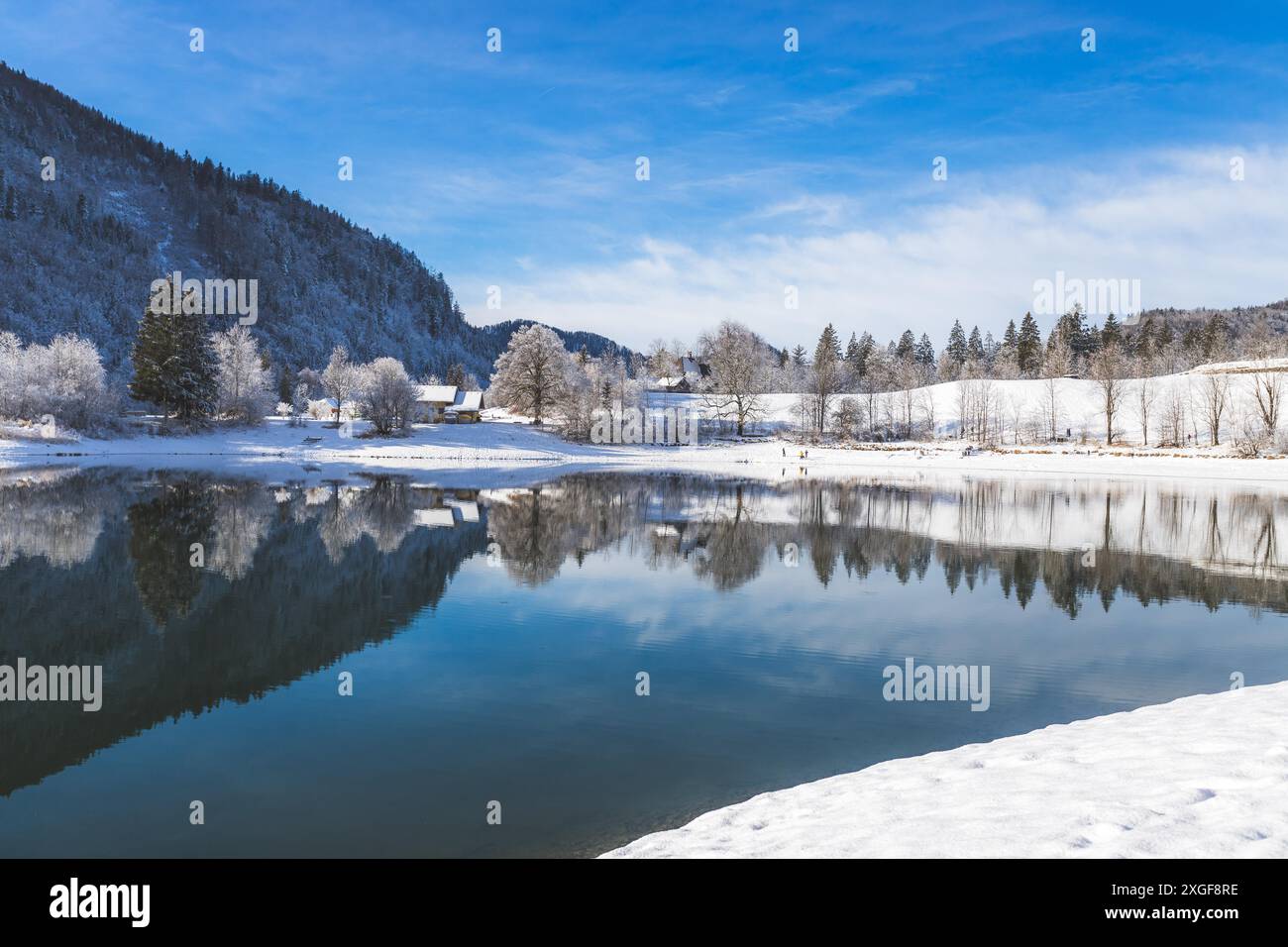 Idyllic winter landscape: Reflection lake, house and snowy trees and ...