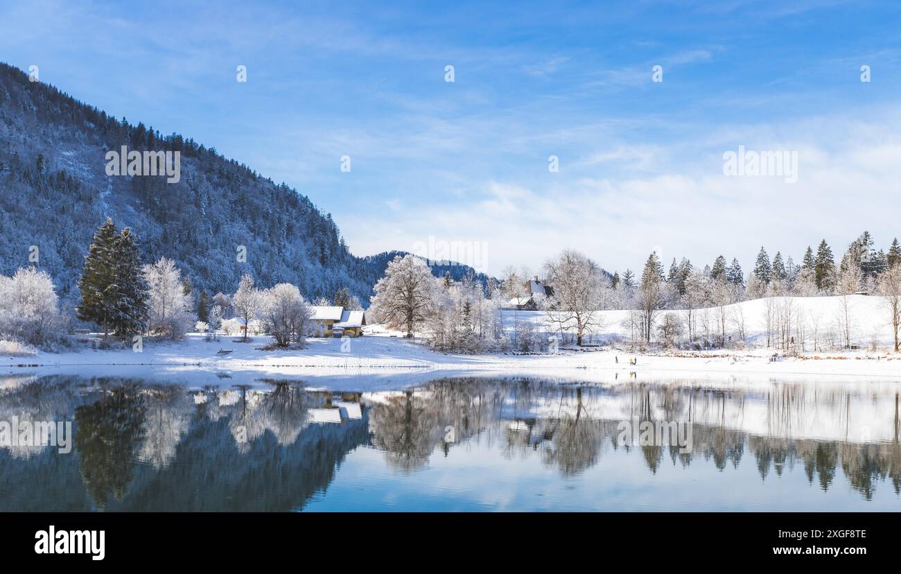 Idyllic winter landscape: Reflection lake, house and snowy trees and ...