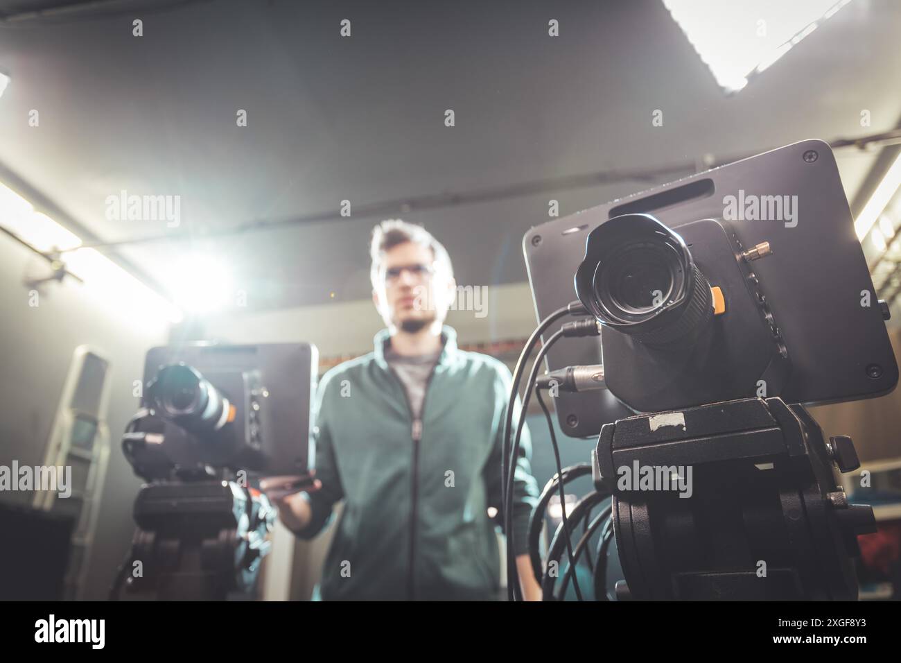 Male cameraman is operating a film camera in a television recording ...