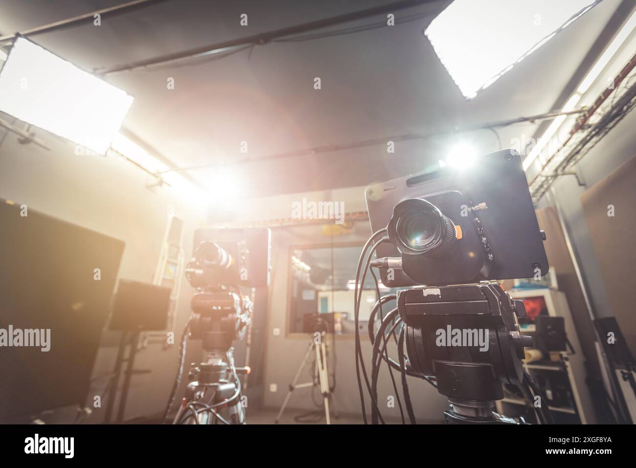 Film camera on a tripod in a television broadcasting studio, spotlights ...