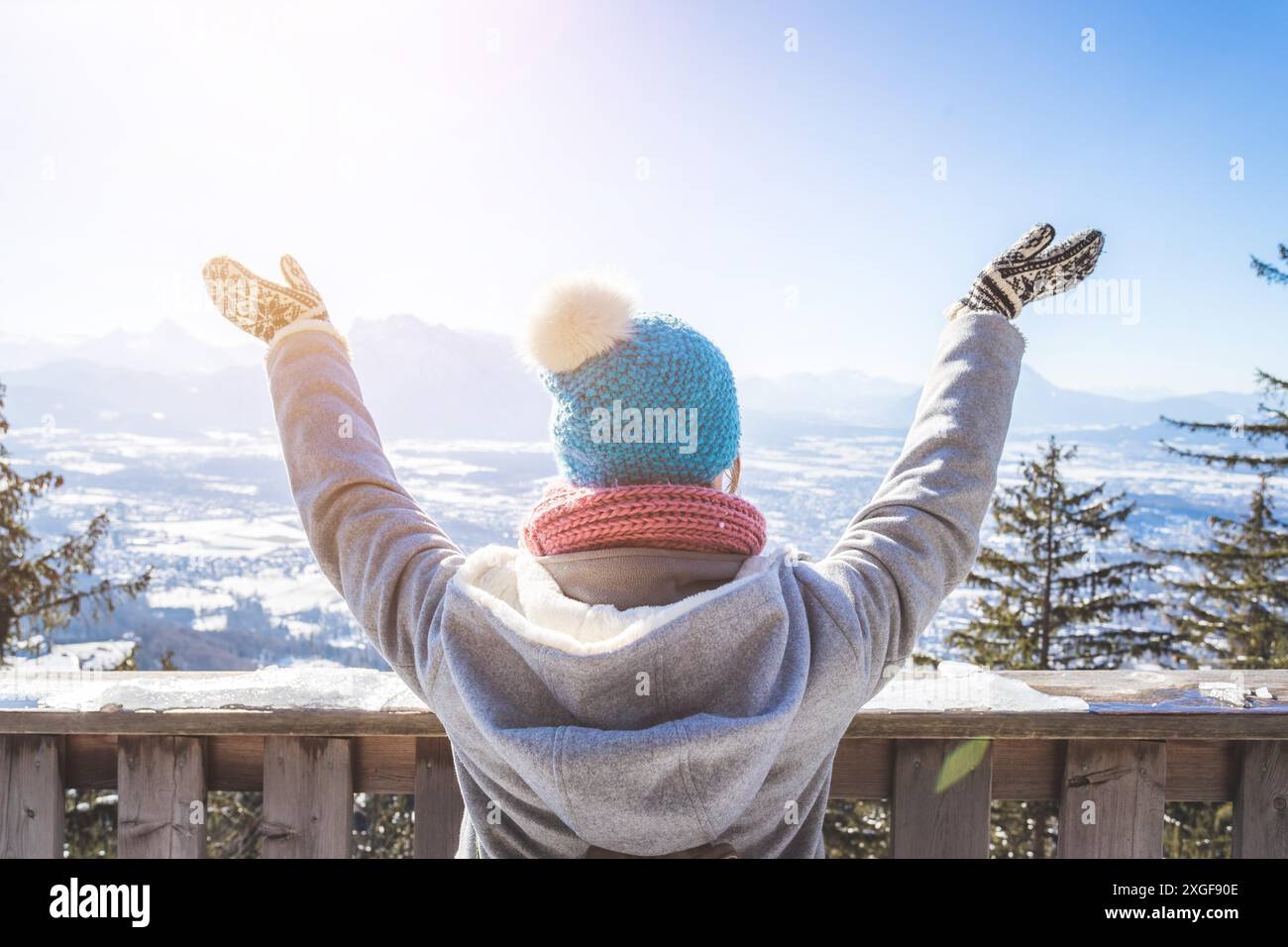 Back of young woman who is raising her hands on the mountain, outlook ...