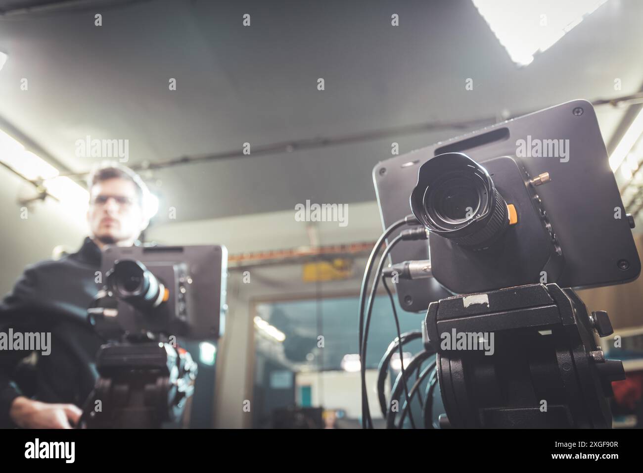 Male cameraman is operating a film camera in a television recording ...