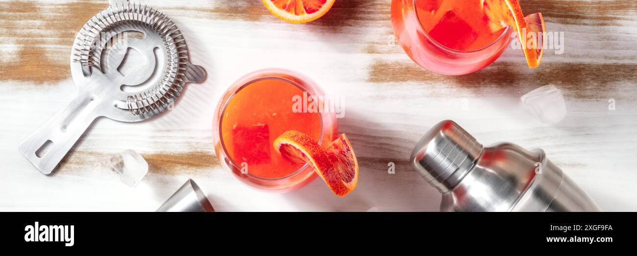 Orange cocktail panorama with a shaker and a jigger, overhead flat lay ...