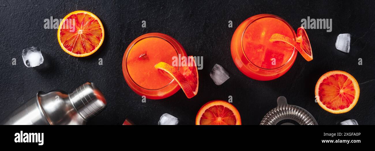 Orange cocktails panorama with ice cubes, shot from above on a black ...