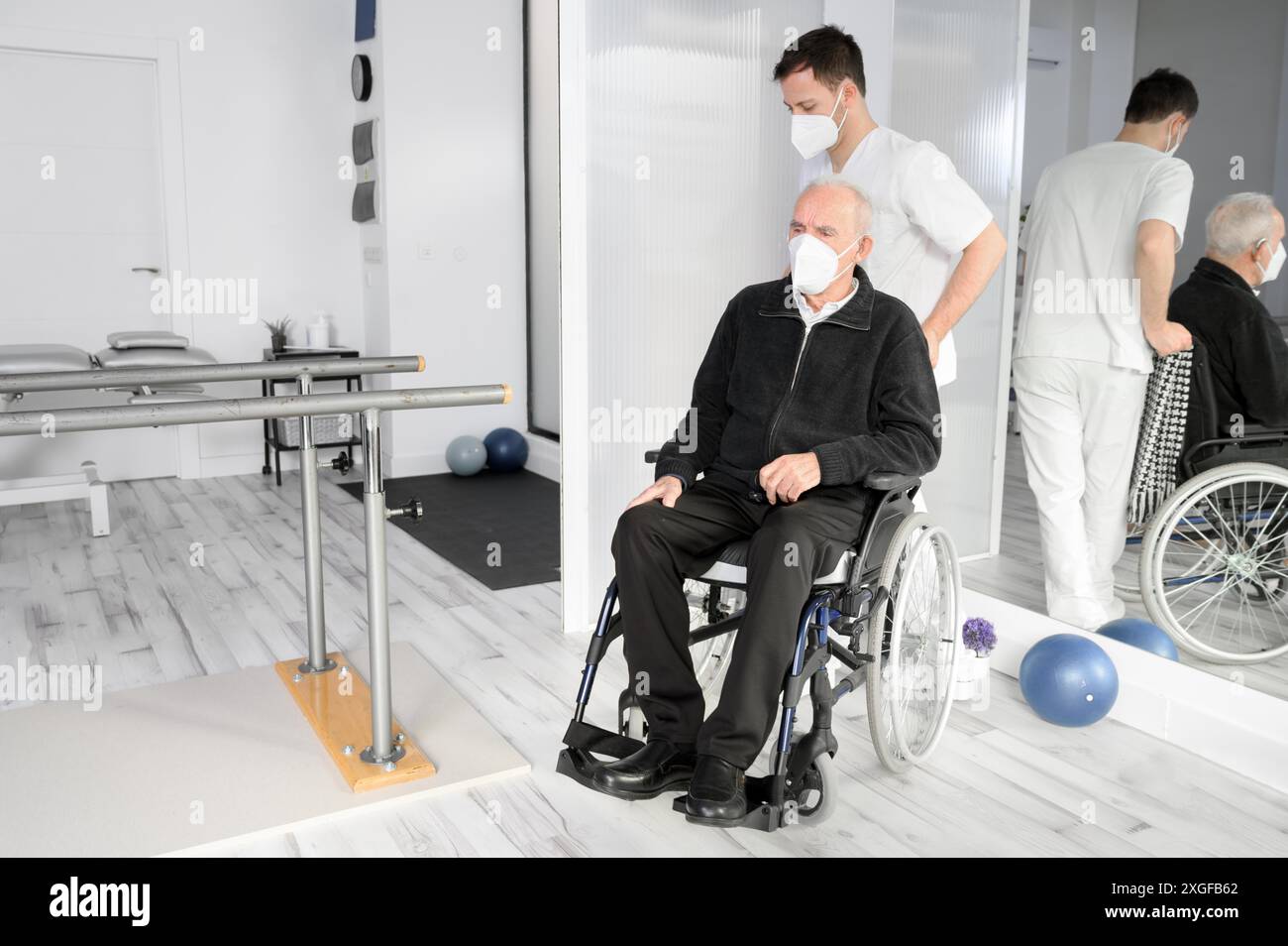Male Nurse assisting a senior handicapped patient in wheelchair at ...