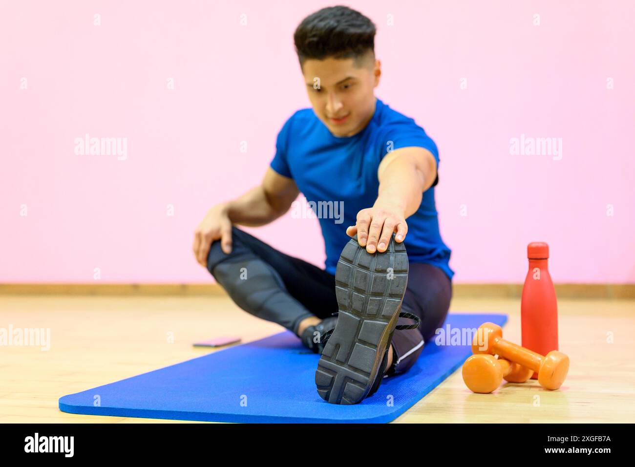 Portrait of a fitness man doing stretching exercises at gym. High ...