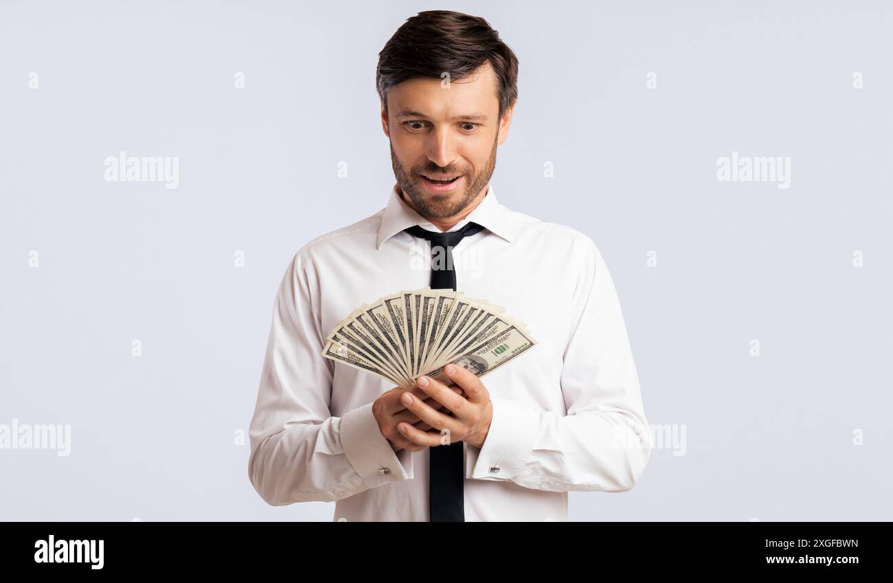 Man Holding Fan of Cash in White Shirt Stock Photo - Alamy