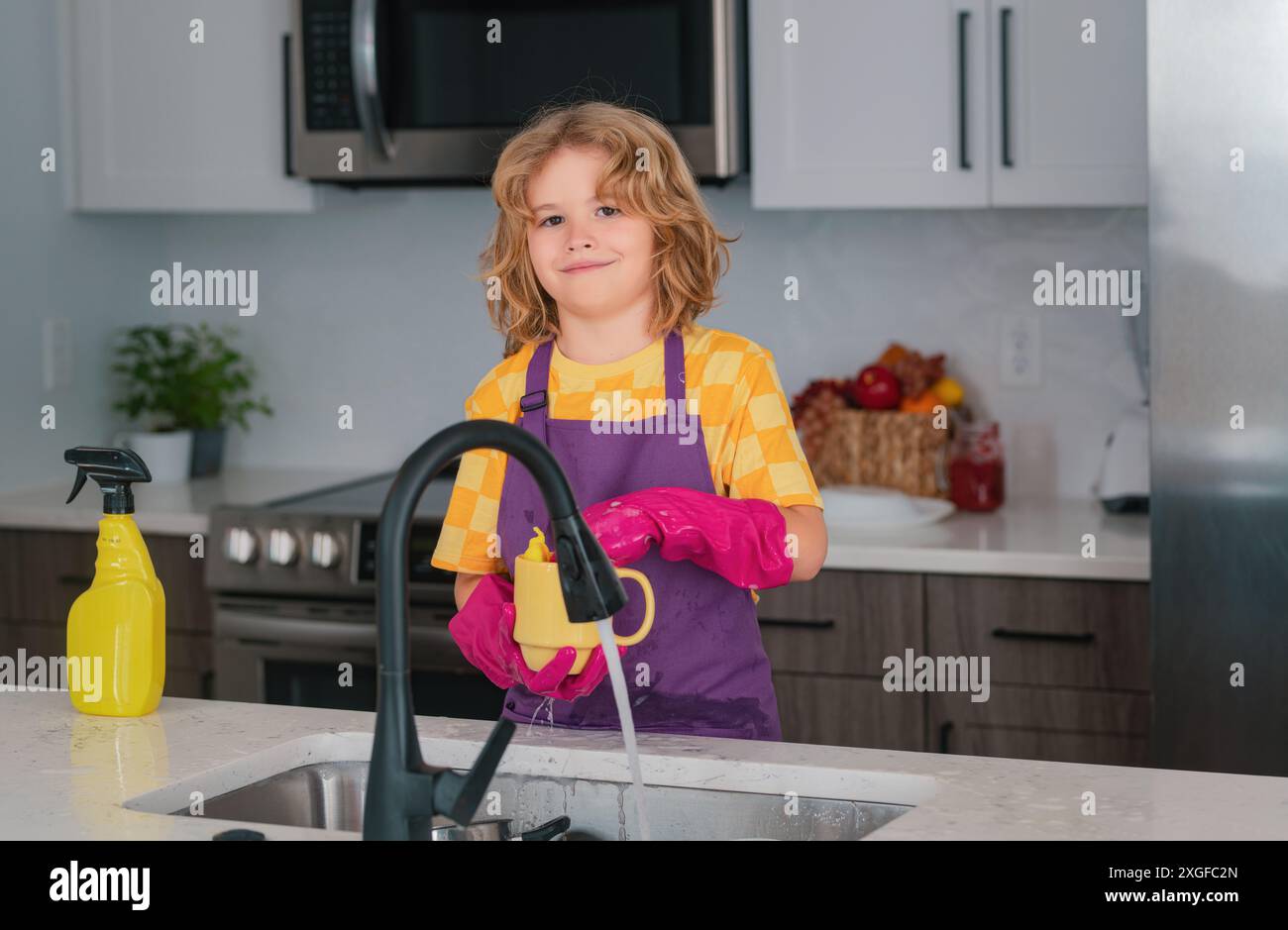 Clean dishes. Child doing and wiping dishes in kitchen. Little kid ...