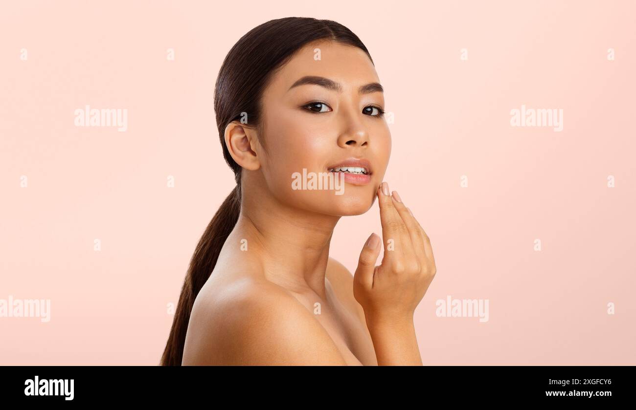 Young Woman With Brown Hair Touching Her Face Stock Photo - Alamy
