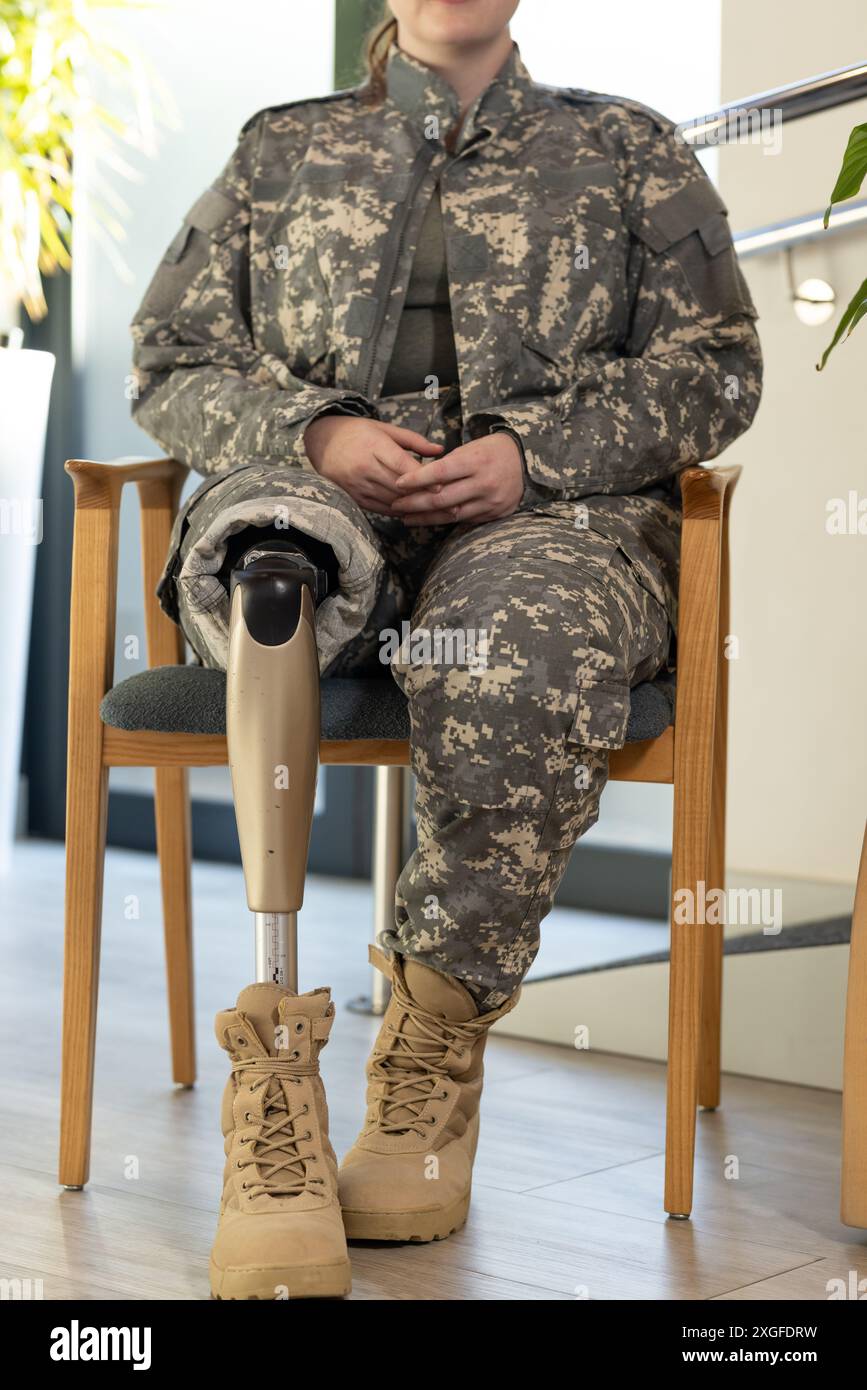 Military soldier personnel with prosthetic leg sitting on chair ...