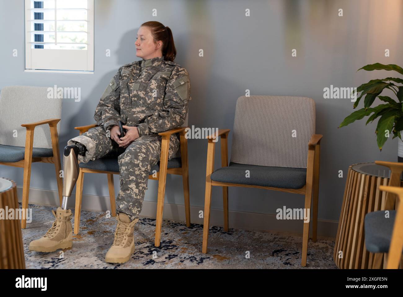 Sitting in waiting room, woman in undefined uniform with prosthetic leg ...