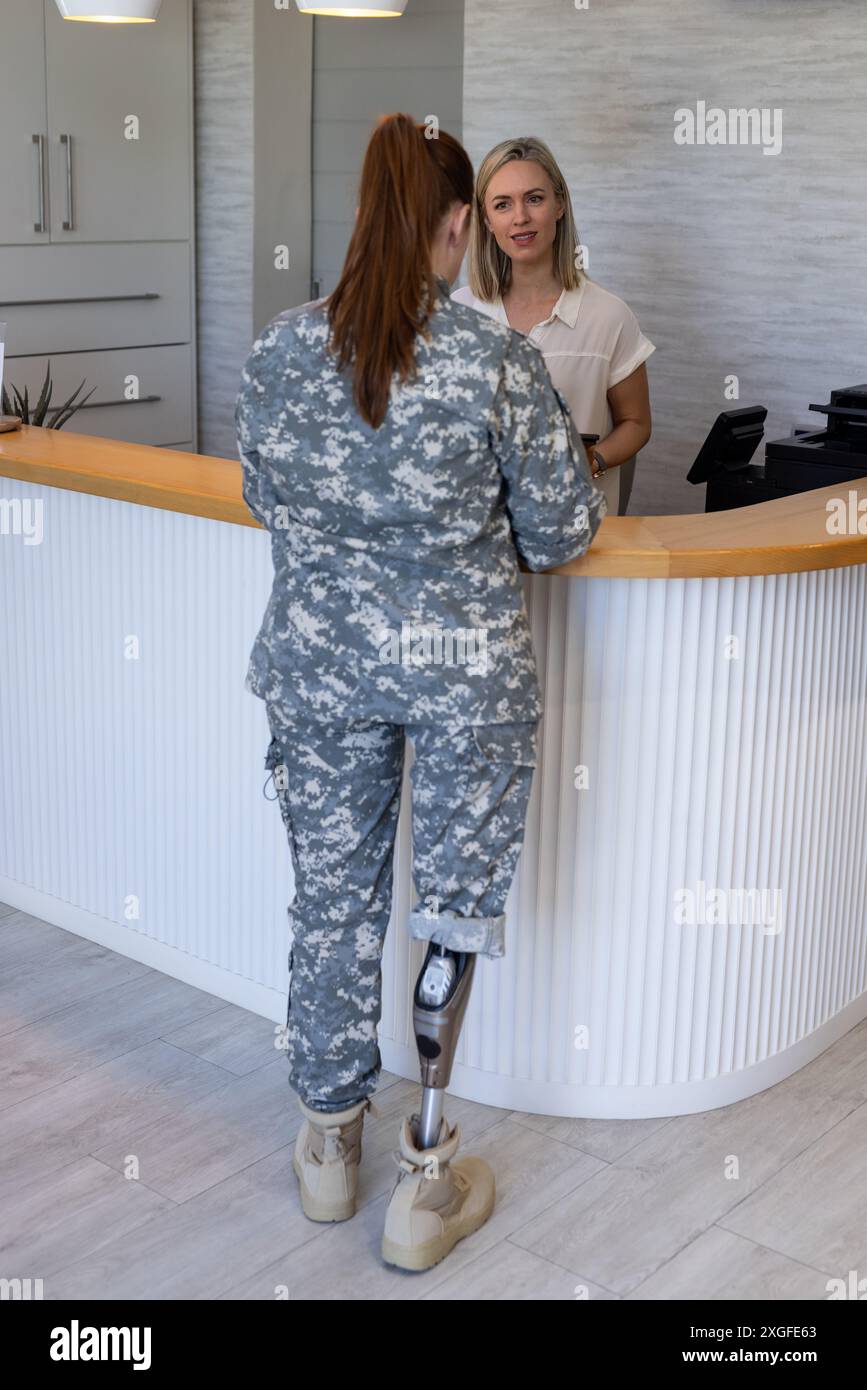 Military soldier woman with prosthetic leg talking to receptionist at ...